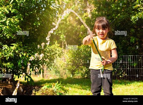 Niña Feliz Jugando Con Una Manguera De Jardín Niño Preescolar