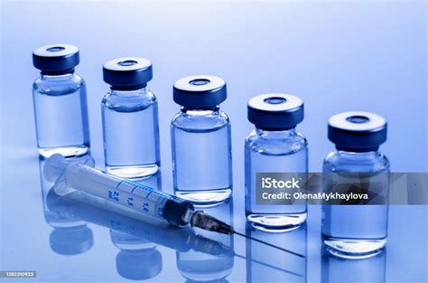 ワクチン用量インフルエンザとして液体薬を用いてバイアルは医療テーブル上の注射治療のための注射器と一緒に撮影しましたワクチン接種または予防接種