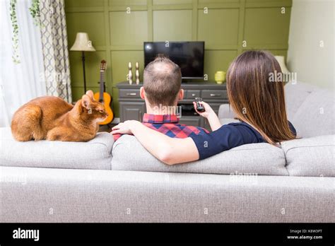 Beautiful Couple Watching TV Sitting On Couch At Home Stock Photo Alamy