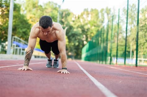 Premium Photo Young Athletic Man With A Naked Torso Doing Pushups In