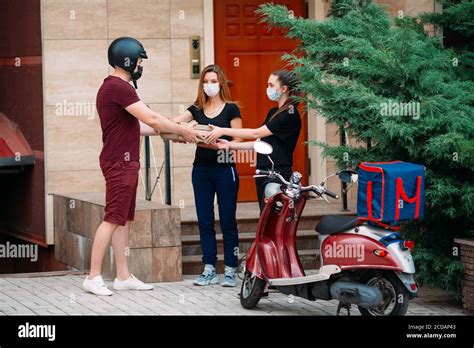 Two Womans Pick Up Delivery Food Box From Delivery Rider With Scooter