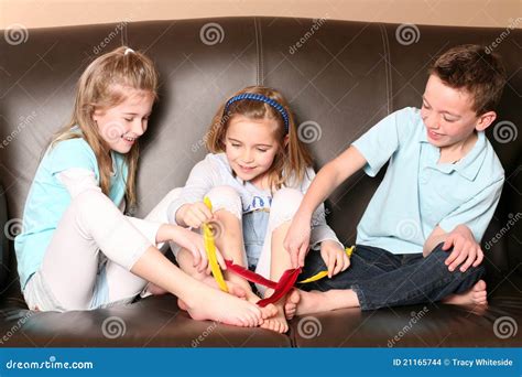 Niños Que Cosquillean Pies Con La Pluma Foto De Archivo Imagen De