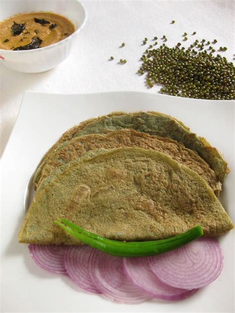 Some Food Is On A White Plate With Green Peppers And Sauces Next To It
