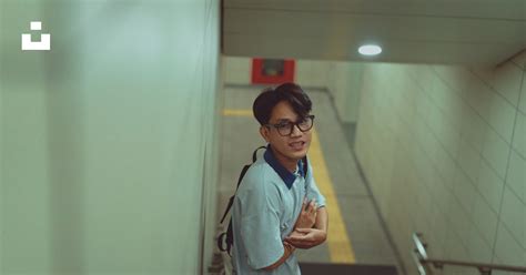 파란 셔츠와 안경을 쓴 남자가 에스컬레이터에 서 있다 사진 Unsplash의 무료 베트남 이미지