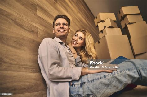 잘 생긴 세련된 남자와 아름다운 소녀는 바닥에 앉아 집 이동 후 휴식 2명에 대한 스톡 사진 및 기타 이미지 2명 가구 가정 생활 Istock