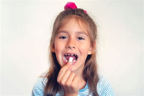 Premium Photo Cleaning Your Teeth With Chewing Gum Girl Puts White