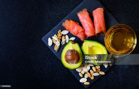 검은 접시에 건강한 지방 공급원 아보카도 연어 견과류 올리브 오일의 선택 건강한 식습관의 개념 맨 위 보기 복사 공간 검은 색