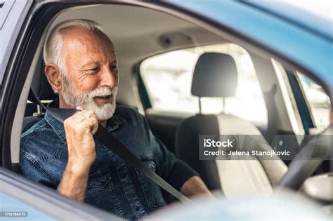 새 차의 운전석에 앉아 편안함을 느끼는 행복한 남자 운송 및 복사 공간을 위해 차량을 운전하는 안전 벨트를 매고 웃고 있는