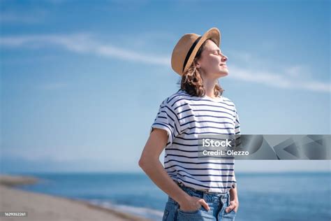 푸른 바다의 황량한 모래 해변을 따라 걷는 모자를 쓴 젊은 행복한 여자 여름 방학 및 여행 걷기에 대한 스톡 사진 및 기타 이미지 Istock