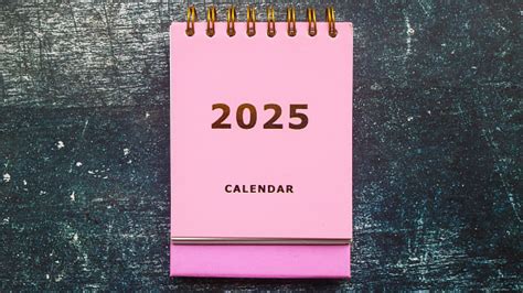 2025 달력 분홍색 테이블에 고립되어 있습니다 달력과 메모장 2025년 새해 복 많이 받으세요 2025년 새해 결심 목표 계획