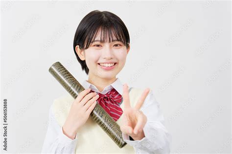白背景で卒業証書の筒を持ってピースサインする女子高生 Foto De Stock Adobe Stock