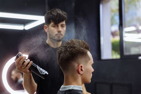 Premium Photo Barber Makes Hair Styling With Hair Spray After Haircut