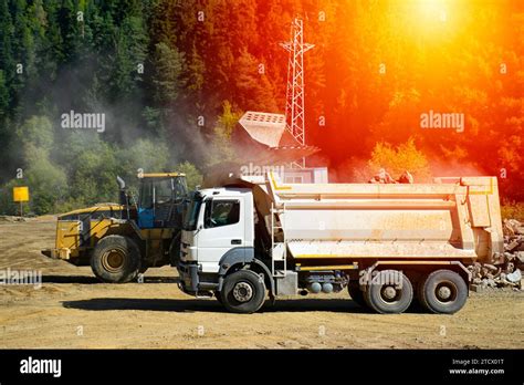 The Excavator Loads Crushed Stone In A Dump Truck Body Loading Stones