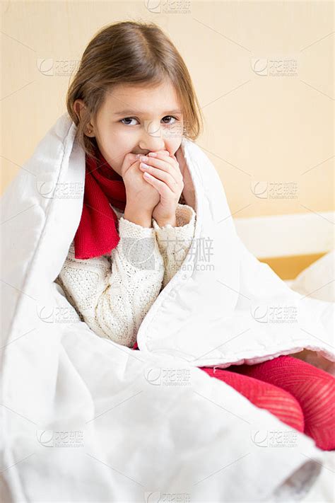 生病的女孩裹着毯子在床上咳嗽