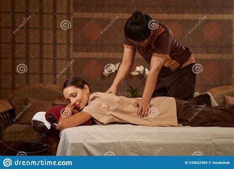Experienced Massotherapist Giving Female Patient Thai Massage Stock