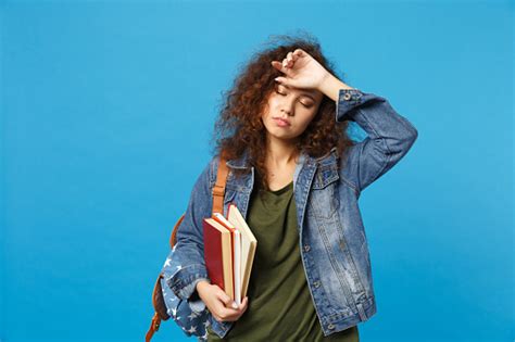 데님 옷에 젊은 슬픈 아프리카계 미국인 소녀 사춘기 학생 배낭은 파란색 배경 스튜디오 초상화에 고립 된 책을 보유 고등학교 대학 대학 개념에서 교육 복사 공간을 모의 합니다