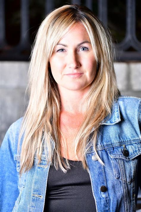 Woman Smiling In A Blue Denim Jacket With Long Blonde Hair Outside At Night Stock Photo Image