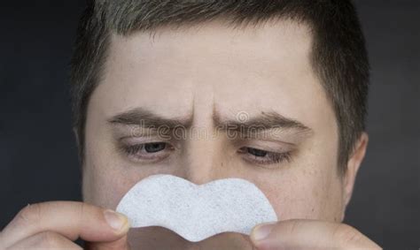 A Man Puts On And Removes A Strip For The Nose From Black Dots Coal