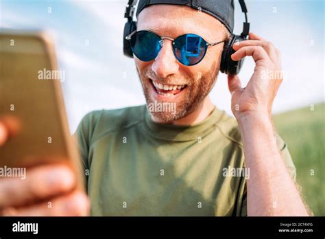 Cool Man In Baseball Cap Wireless Headphones And Blue Sunglasses