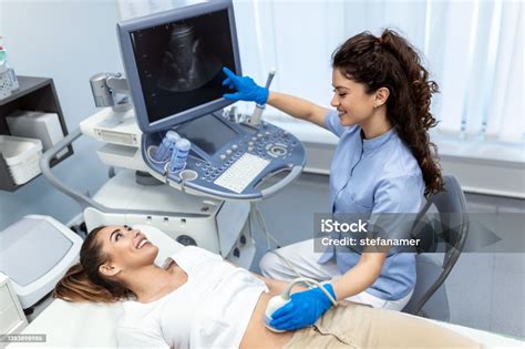 병원에서 여성에게 복부에 위장의 초음파 진단 클로즈업 보기 의사는 환자의 소녀 배를 통해 초음파 센서를 실행하고 화면에 이미지를 본다 내부 장기의 진단 초음파에 대한 스톡