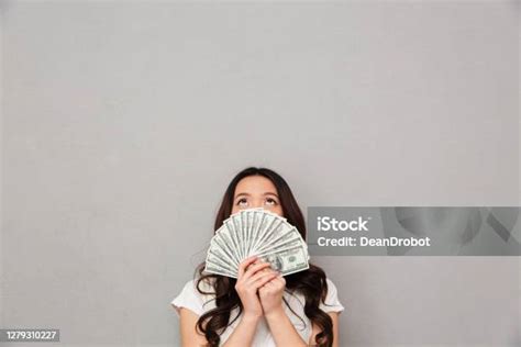 돈 달러 지폐의 팬과 얼굴을 덮고 회색 배경에 고립 된 위쪽을 바라보는 아시아 부자 여성 20 대 사진 T 셔츠에 대한 스톡