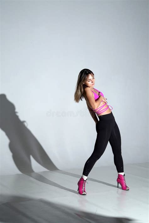 Young Woman Wearing A Bright Pink Bra Top Leggings And High Heels