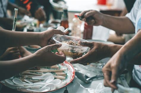 Las Manos De Los Voluntarios Ofrecen Comida Compartida A Los Pobres