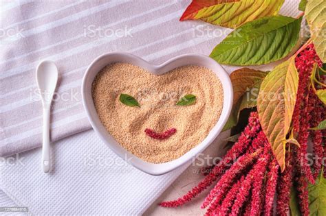 아마란스는 꽃이 만발한 가지 아마란스와 함께 심장의 형태로 희미한 흰색 접시에 그릿 0명에 대한 스톡 사진 및 기타 이미지