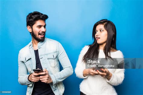 인도 커플 입력 에 그들의 전화 보이는 각각의 고립 된 에 푸른 배경 금 금속에 대한 스톡 사진 및 기타 이미지 금 금속 남자 친구 사람들 Istock