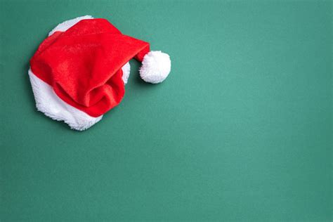 녹색 배경에 빨간 산타 클로스 모자 맨 위 보기입니다 공간을 복사합니다 강림절 시간 새해 구성 겨울 방학 축하 장식 크리스마스 인사말 카드 12월에 대한 스톡 사진 및 기타