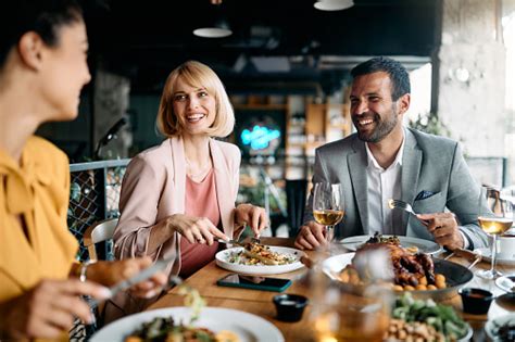 レストランで昼食を食べながら話す幸せなビジネス仲間 レストランのストックフォトや画像を多数ご用意 レストラン ビジネスランチ 食事する Istock