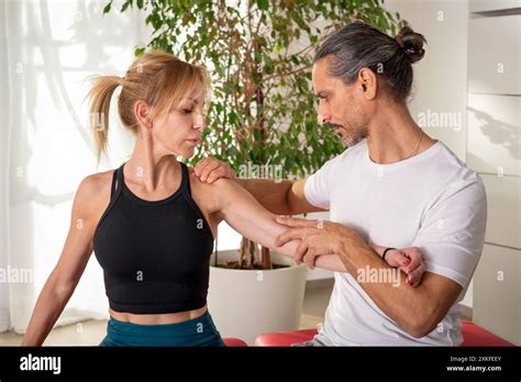 Professional Physiotherapist Performing A Manual Shoulder Assessment On