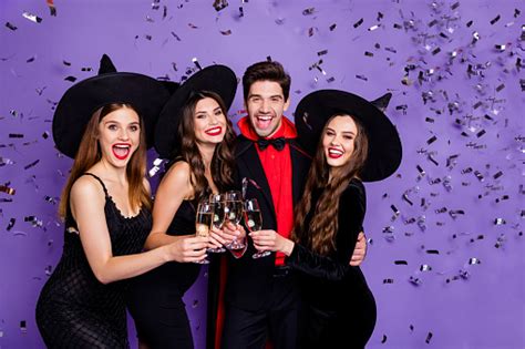 헬로 원 이벤트에서 세 마녀 숙녀와 마법사 남자의 사진은 공기 착용 검은 드레스 모자 정장과 긴 코트 고립 보라색 색상 배경에 황금 와인 반짝이를 음료 파티에 대한 스톡