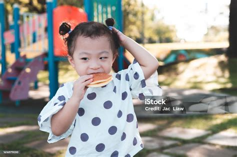 Joyful Asian Twins Embrace Playtime And Snack Times With Loving Mom At