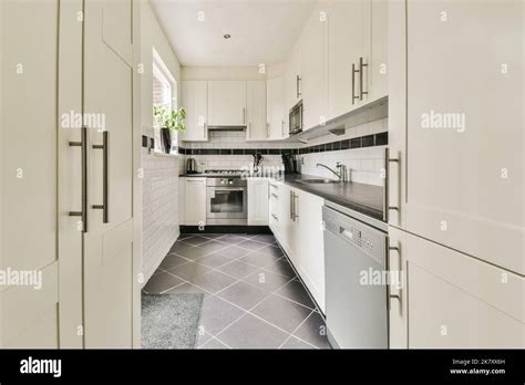 Assorted Cookware And Appliances Placed On Counters With White Cabinets