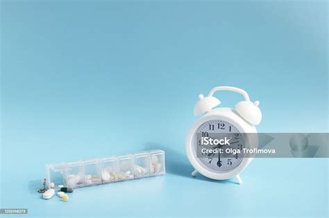 파란색 배경에 흰색 알람 시계 태블릿 및 주간 태블릿 주최자 약을 복용의 시간의 개념 카피스페이스 가까운에 대한 스톡 사진 및 기타 이미지 Istock