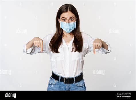 Covid And People Concept Young Woman In Face Mask Pointing Fingers
