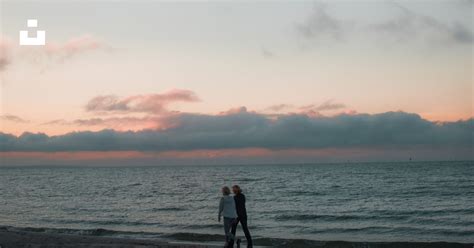 Silueta De La Persona De Pie En La Orilla Del Mar Durante La Puesta Del