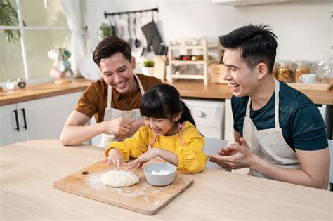 아시아 매력적인 Lgbtq 게이 가족 가르쳐 소녀 아이 만드는 효 모 반죽 잘 생긴 남성 부부는 돌보고 부엌에서 작은 사랑스러운