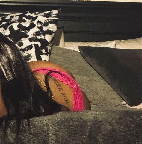 A Woman Laying On Top Of A Bed Next To Pillows