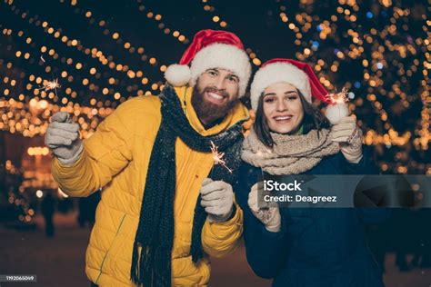 사진 사진 커플 남자 여자 두 사람 Xmas 축 하 공원에서 마술 스파클러를 들고 야외 에서 새해 파티 착용 따뜻한 코트 산타