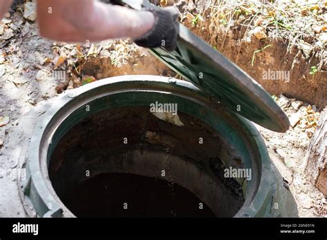 The Man Opens A Sewer Hatch Septic Tank Inspection And Maintenance