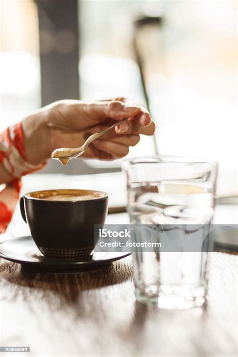 설탕을 저어 준 후 커피 거품이 가득한 숟가락을 복용하는 여성 목재 재료에 대한 스톡 사진 및 기타 이미지 목재 재료 숟가락 카푸치노 Istock