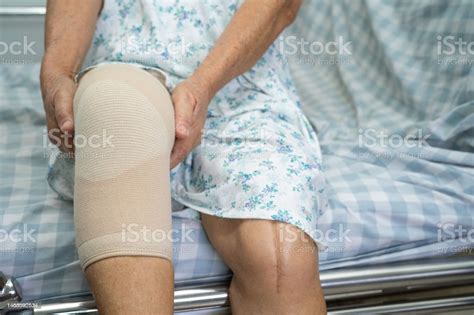아시아 노인 여성 환자는 병원 병동의 침대에서 붕대 압박 무릎 버팀대 지원 부상 건강하고 강한 의료 개념 80 89세에 대한