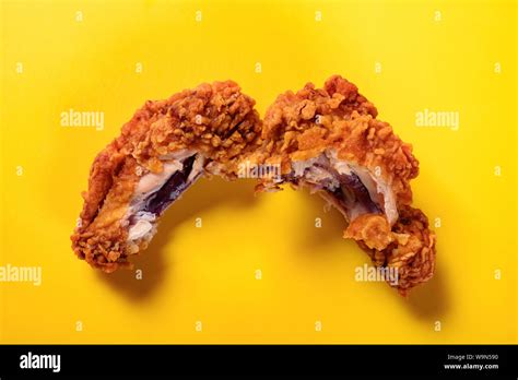 Top View Fresh Deep Fried Chicken Drumstick And Wing With A Bite On Yellow Background Stock