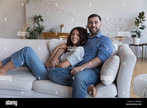 Multi Ethnic Couple Relaxing On Comfortable Couch Smile Pose For Camera