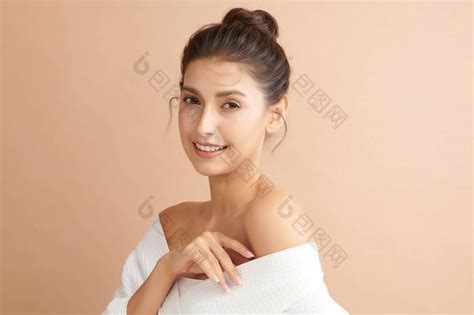 美丽的年轻亚洲女人有着米色背景面部护理面图片 包图网企业站