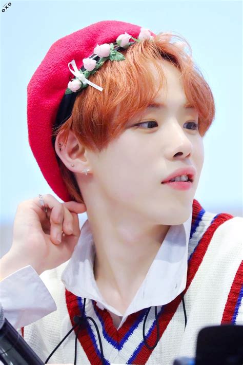 The Young Man Is Wearing A Red Beret With Flowers On Its Head