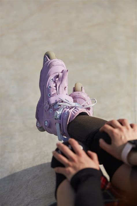 Feet Of A Young Inline Skater Girl Sitting On Top Of A Ramp In A Concrete Skatepark Aggressive