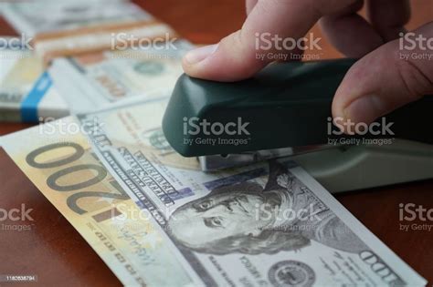 스테이플러는 철 클립으로 달러와 유로 지폐를 고정합니다 지폐의 배경에 종이 클립 스테이플러 경제에 대한 스톡 사진 및 기타